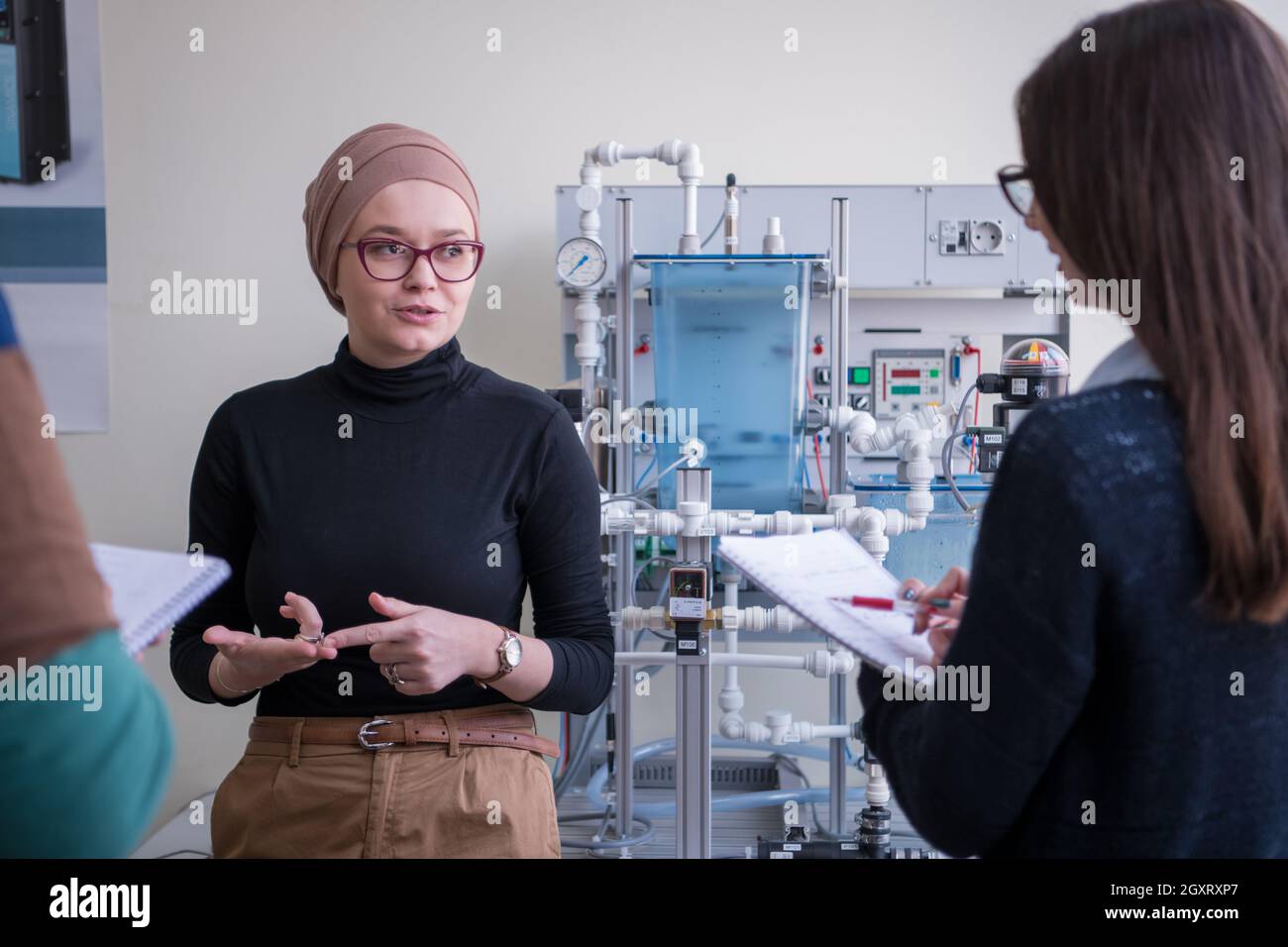 Group of students doing technical vocational practice with young female ...