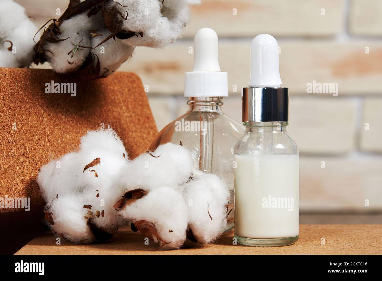 White facial milk in the elegant cosmetics flask on the makeup desk ...