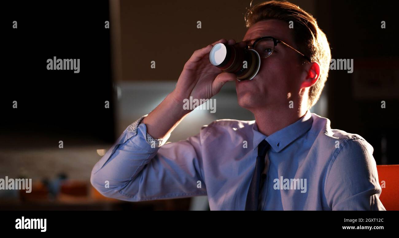 Tired businessman working late doing overtime in office at night ...