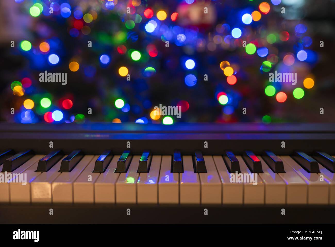 Piano keyboard and Christmas pine tree illuminations. Vibrant colors ...