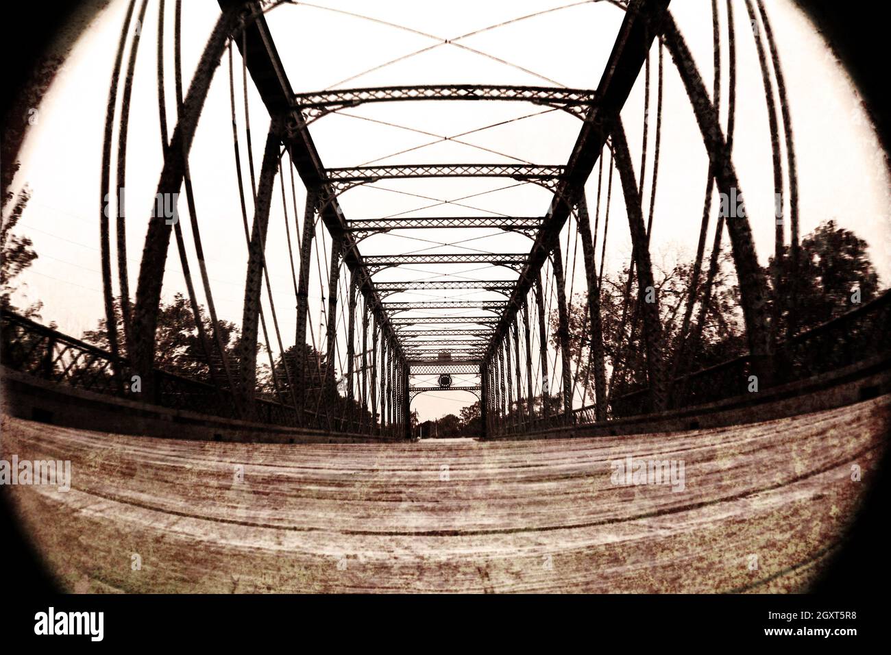 Fish-eye shot from a worm's eye view of a large steel bridge that goes ...