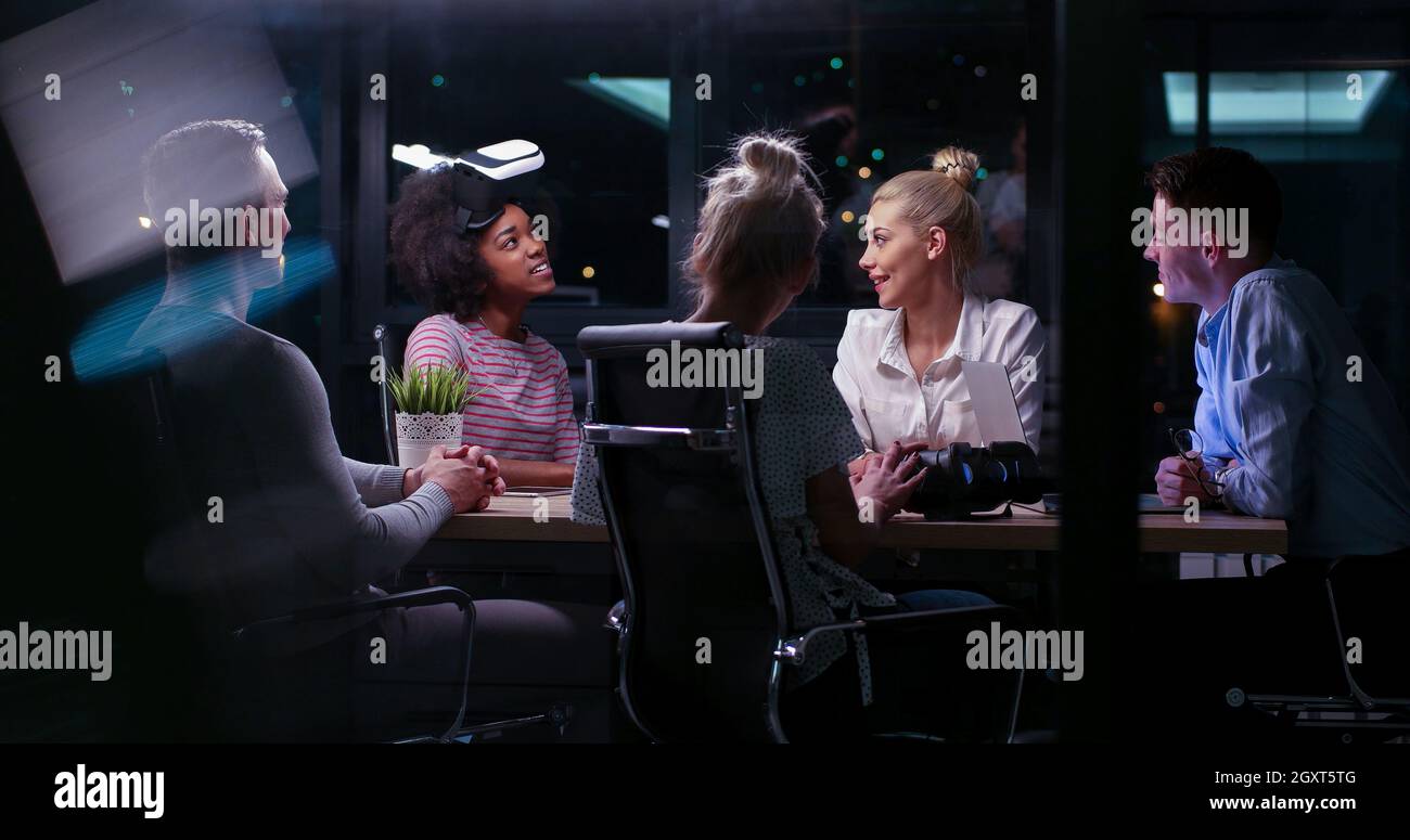 Multiethnic Business team using virtual reality headset in night office ...