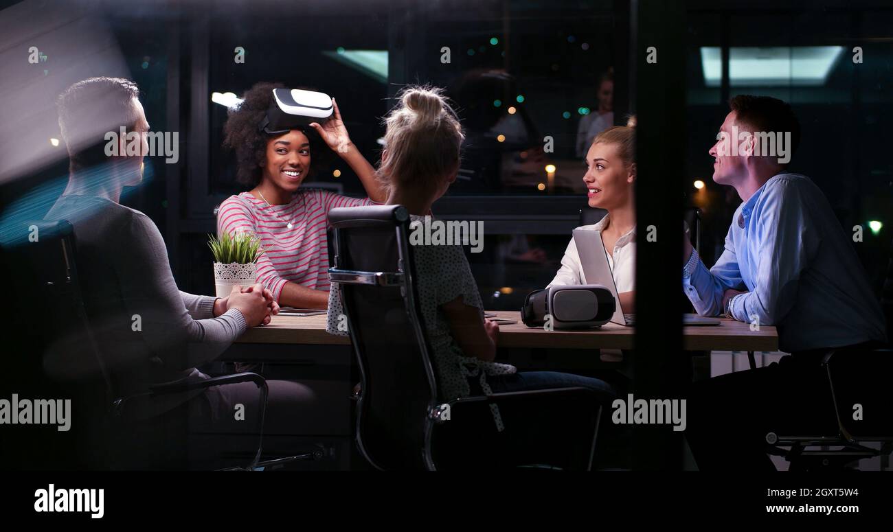 Multiethnic Business team using virtual reality headset in night office ...