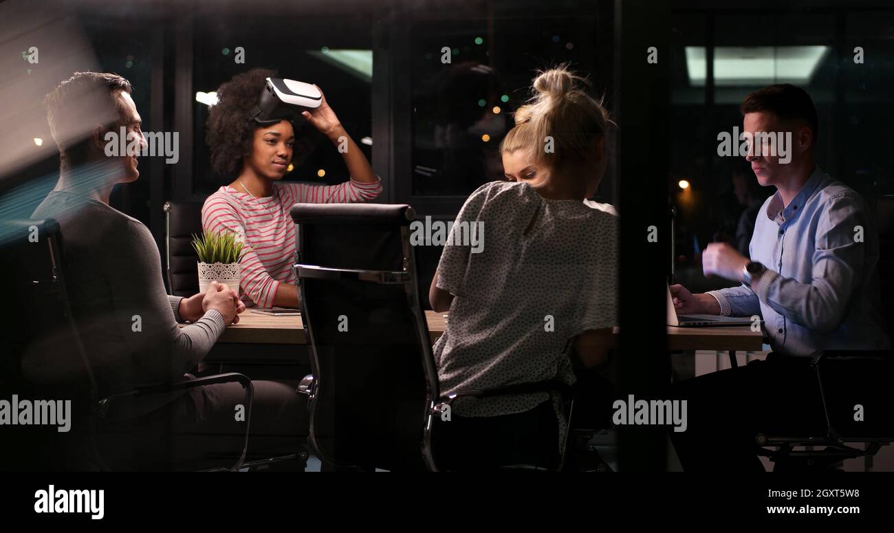 Multiethnic Business team using virtual reality headset in night office ...