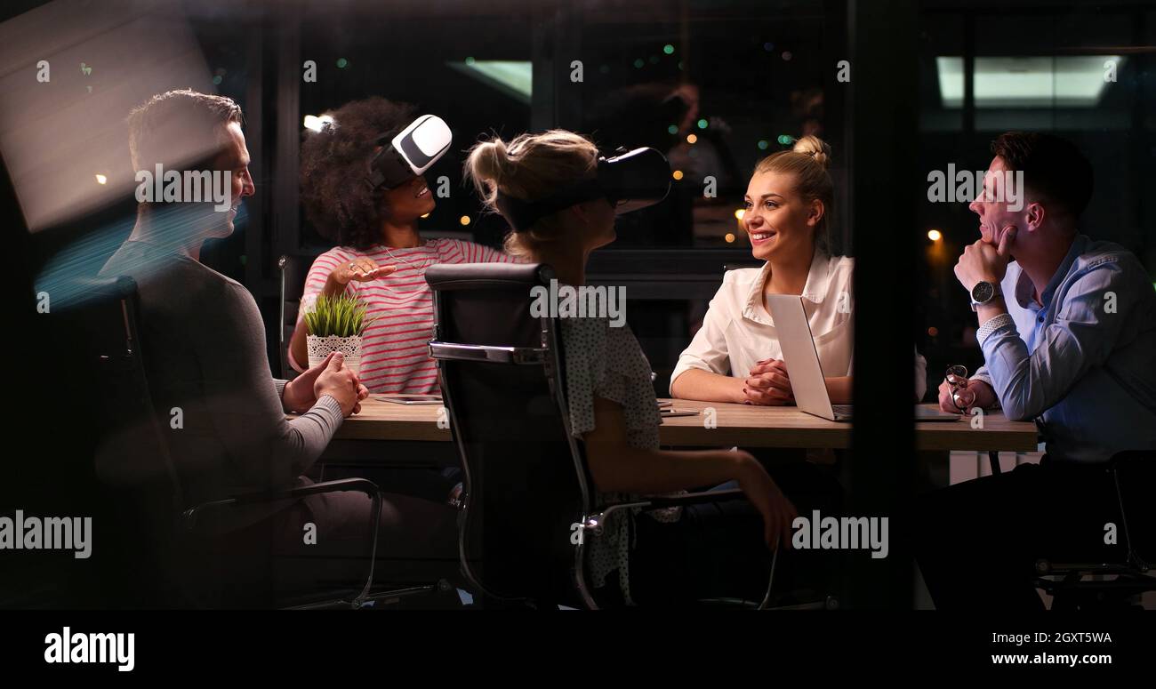 Multiethnic Business team using virtual reality headset in night office ...