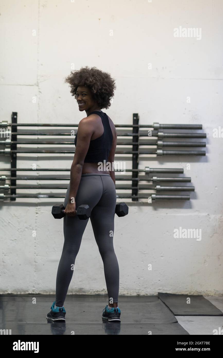 Woman doing bicep curls with dumbbells at a gym hi-res stock ...