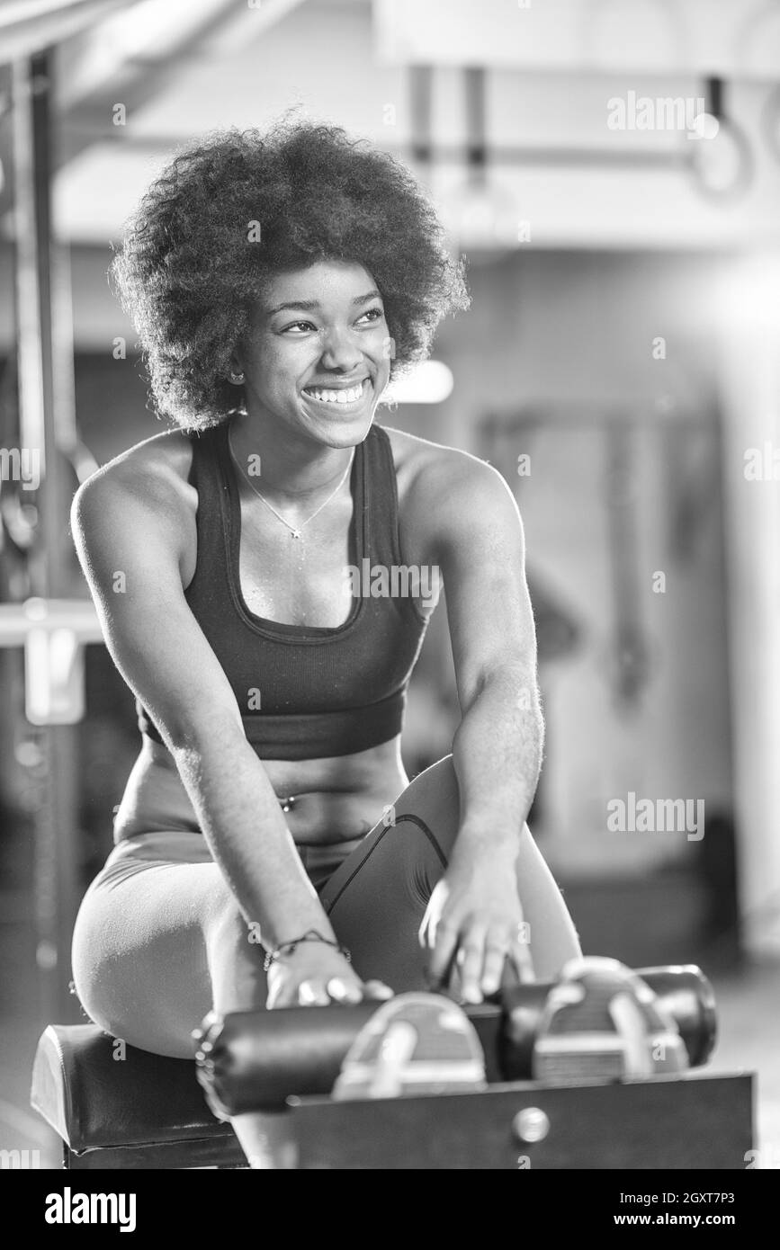 young fit african american woman doing sit ups in fitness studio at the ...