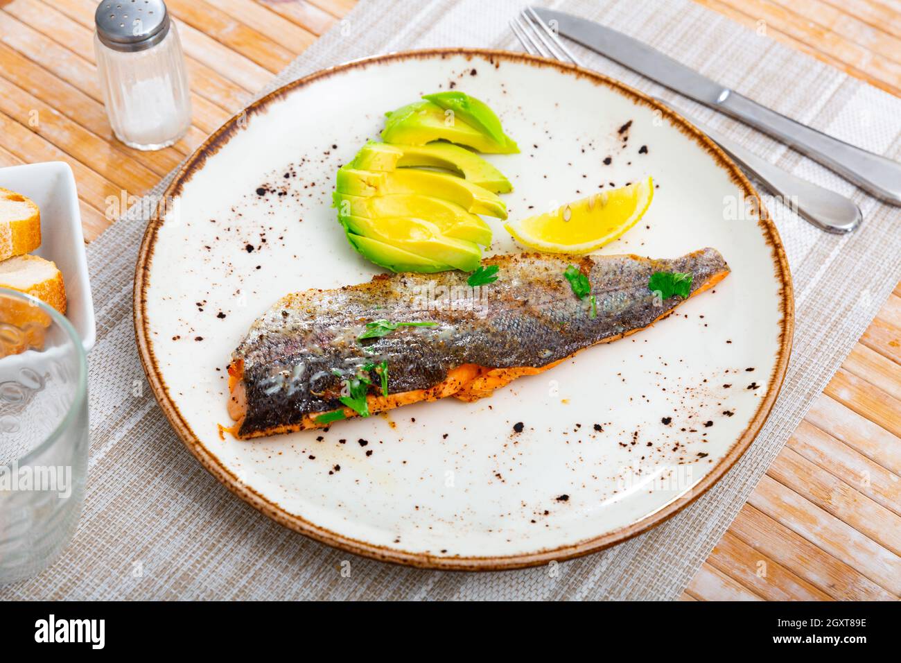 Fried trout fillet served with avocado is healthy dish in kitchen Stock ...