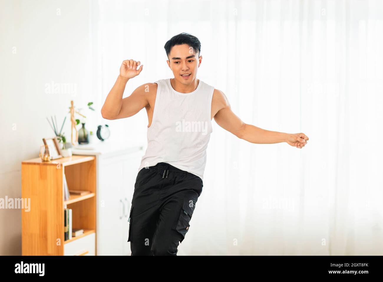 Happy Asian young man Doing Exercises and dancing at Home Stock Photo ...