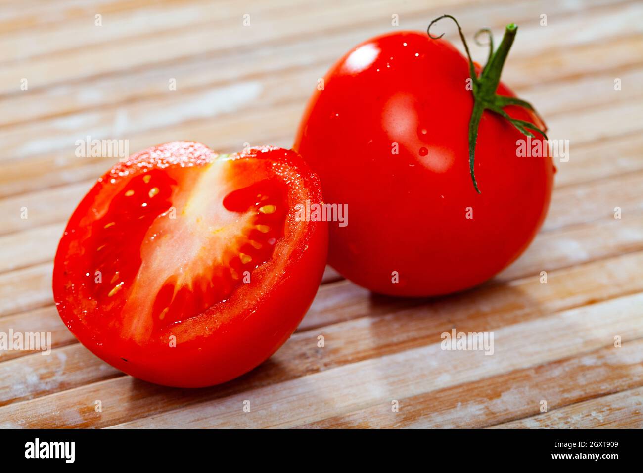 Two red tomatoes on wooden table Stock Photo - Alamy