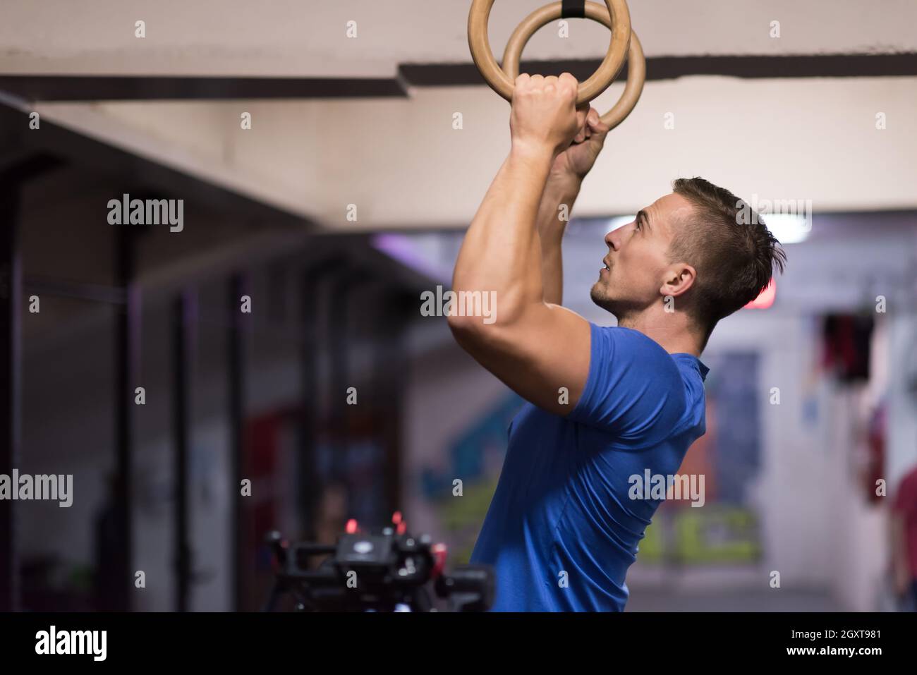 Fitness handsome man doing dipping exercise using rings in the gym ...