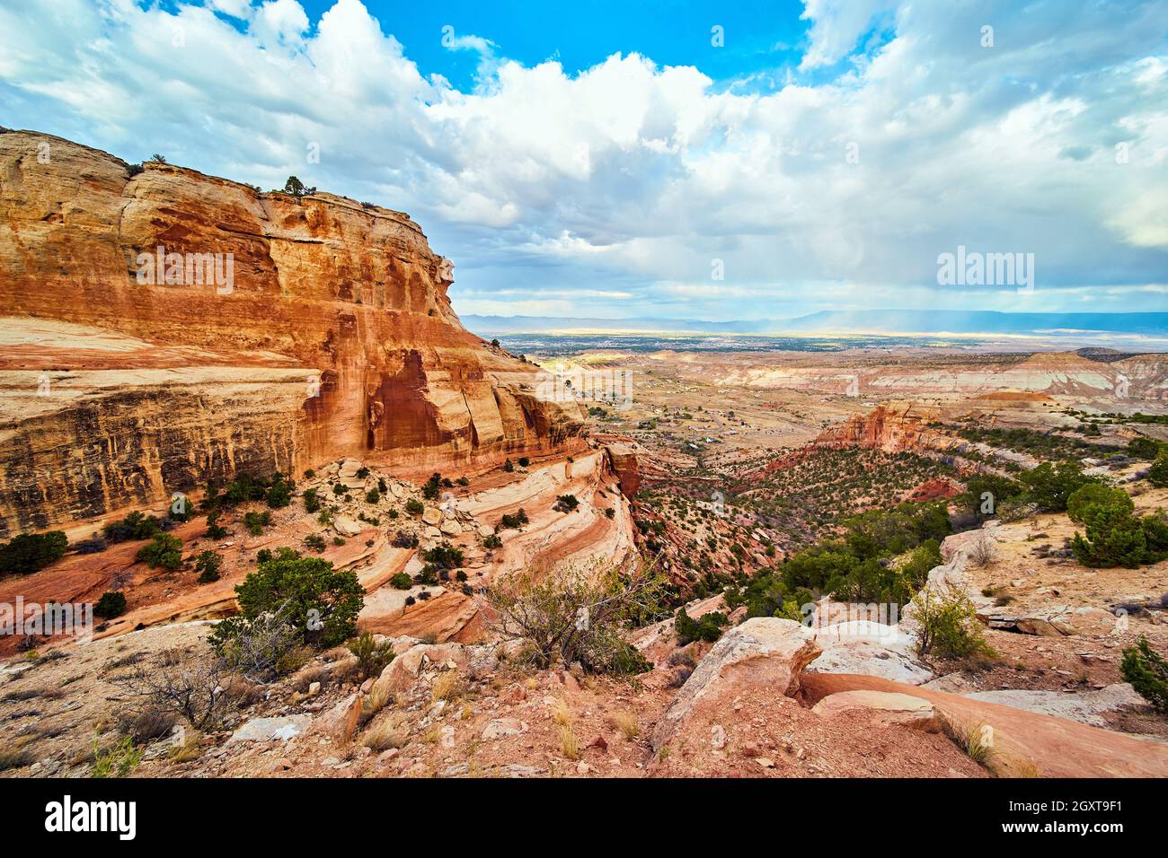 Large red cliffs in desert canyon with open valley and clouds Stock ...