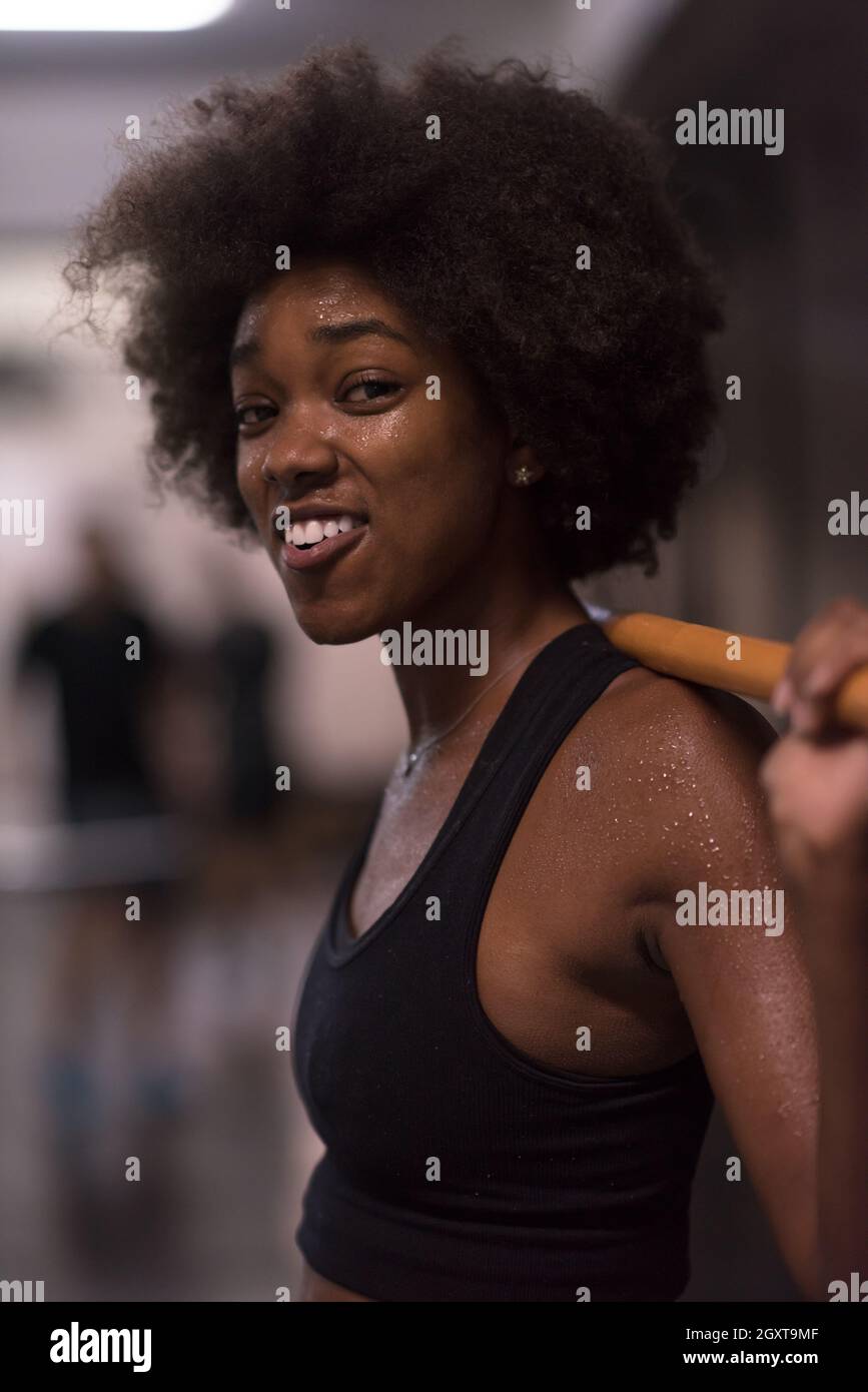 Young Cute african american sport woman in fitness room lifting empty ...