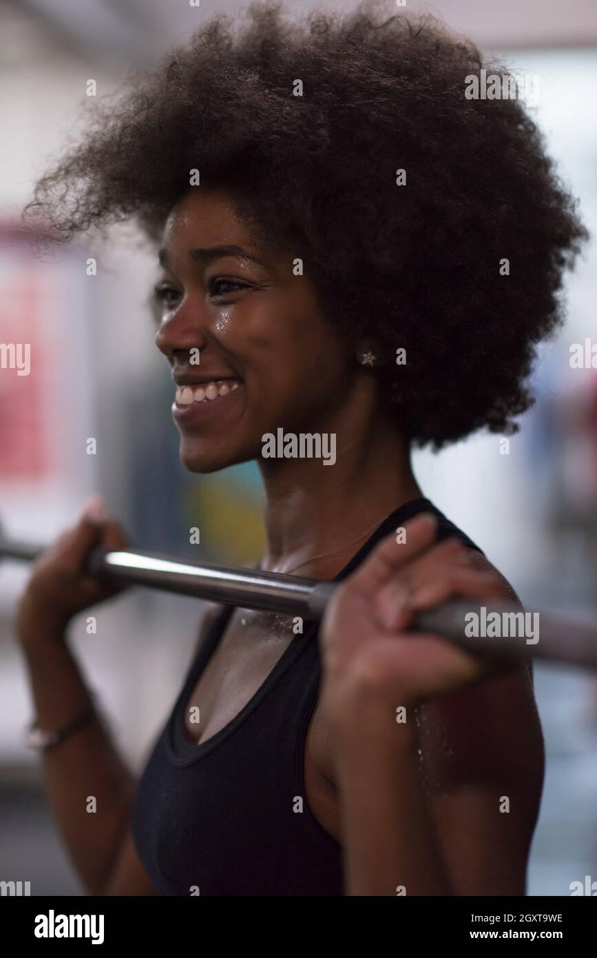 Young Cute african american sport woman in fitness room lifting empty ...