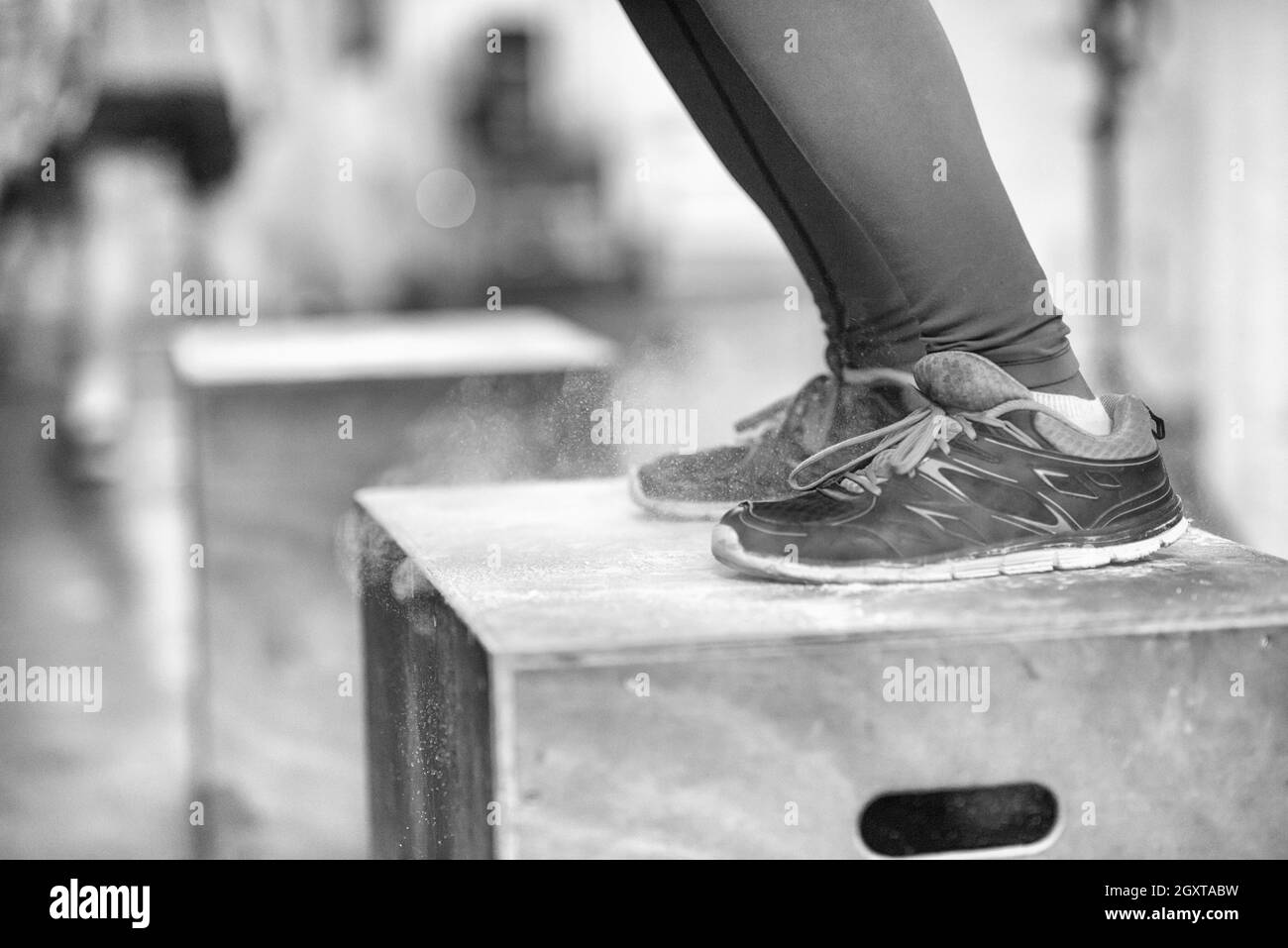 Fit young african american woman box jumping at a crossfit style gym ...