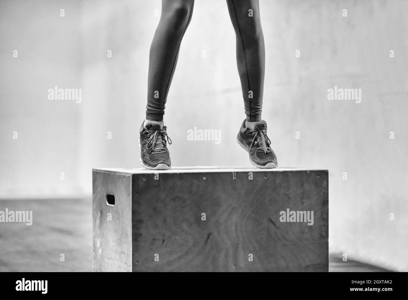 Fit young african american woman box jumping at a crossfit style gym ...