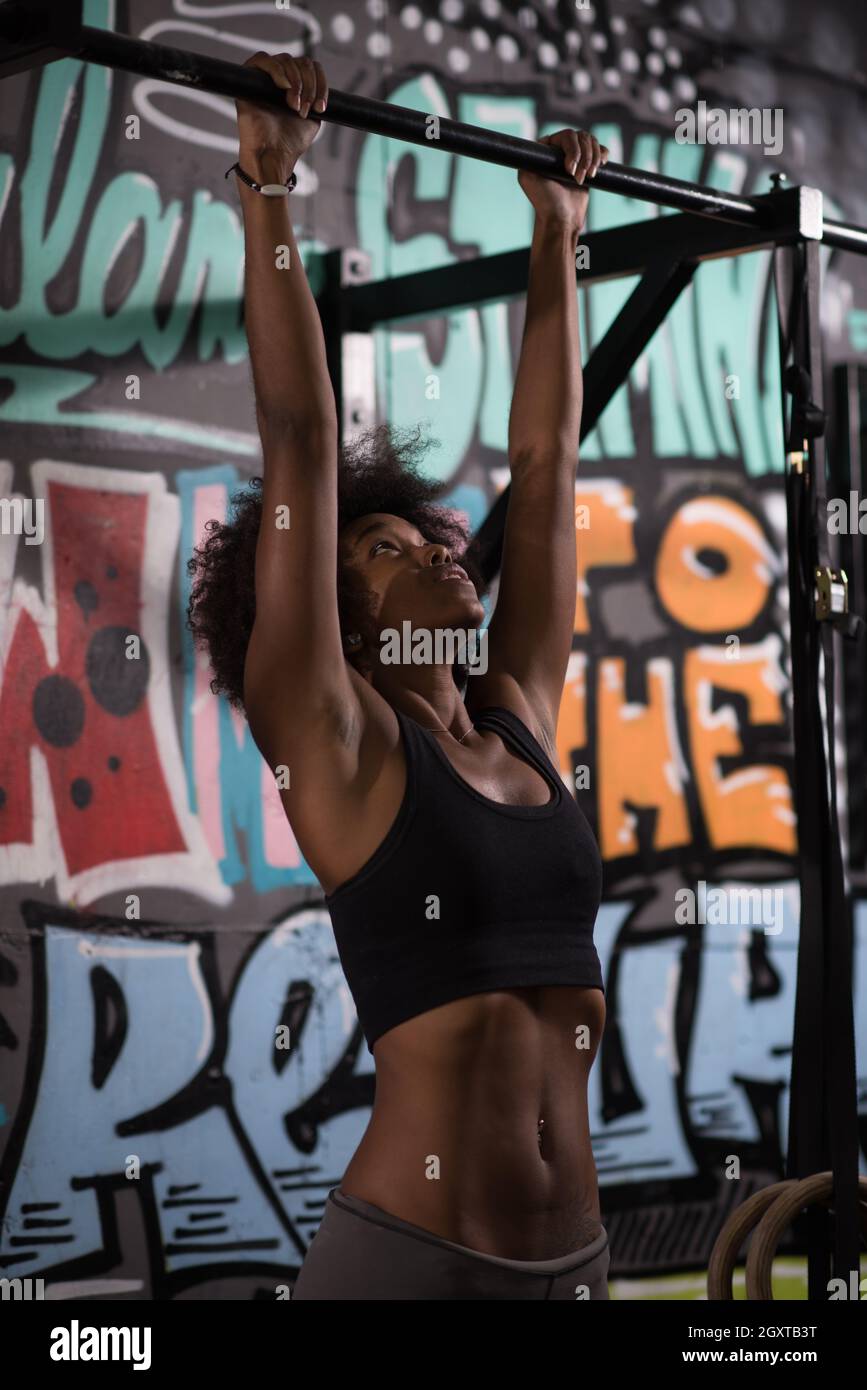 young beautiful african american woman athlete doing pull ups on the ...