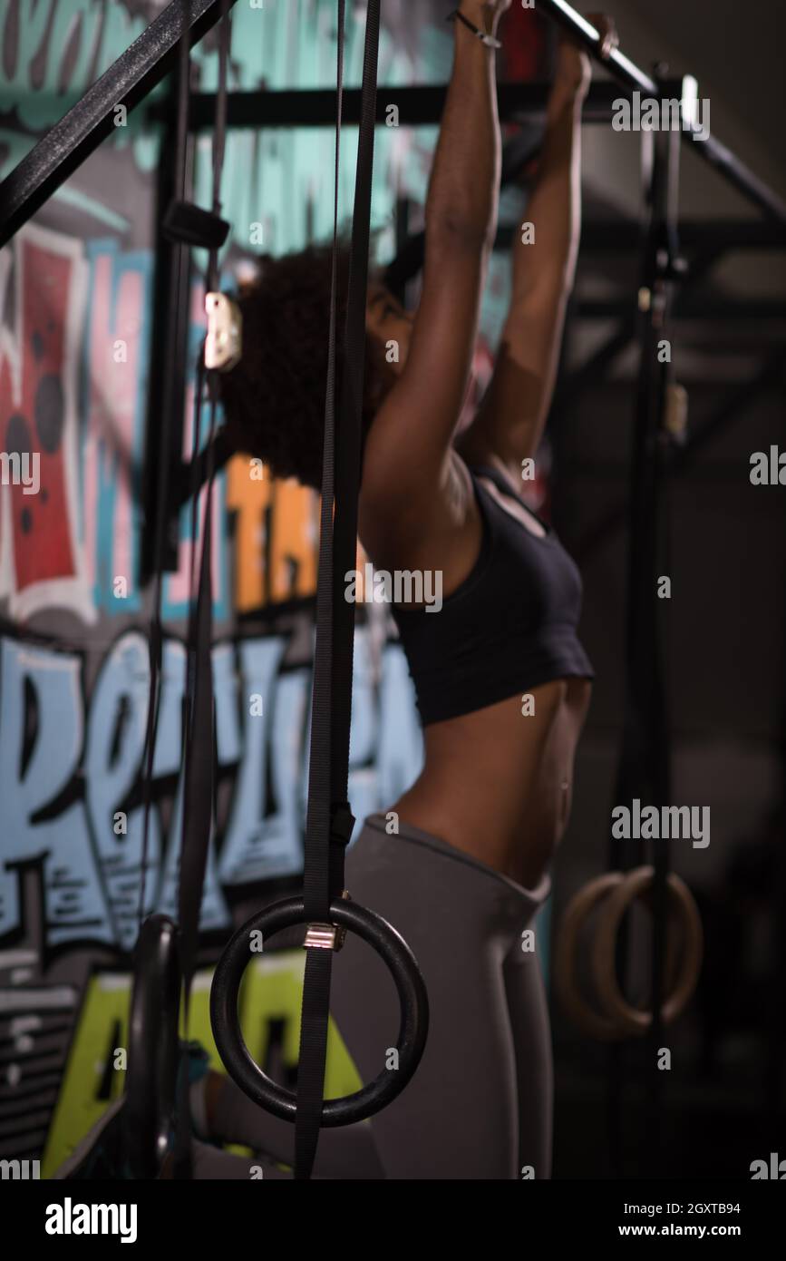 young beautiful african american woman athlete doing pull ups on the ...