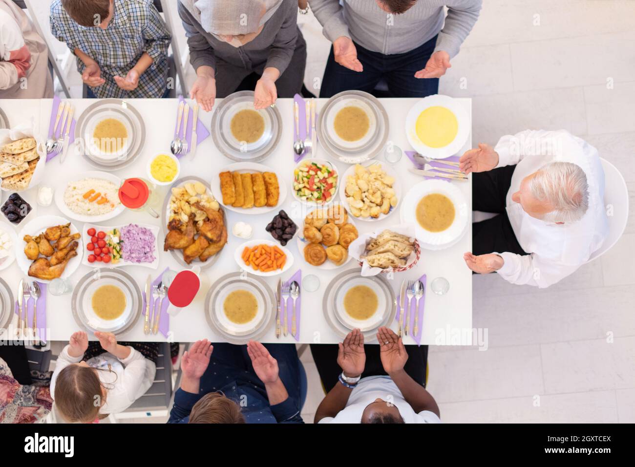 top view of modern multiethnic muslim family praying before having ...