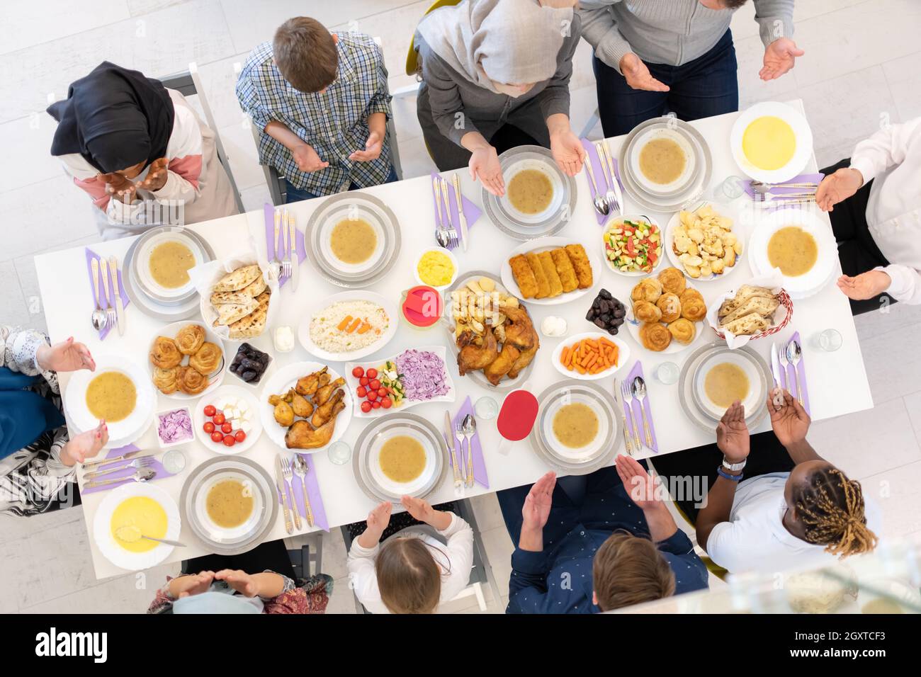 top view of modern multiethnic muslim family praying before having ...