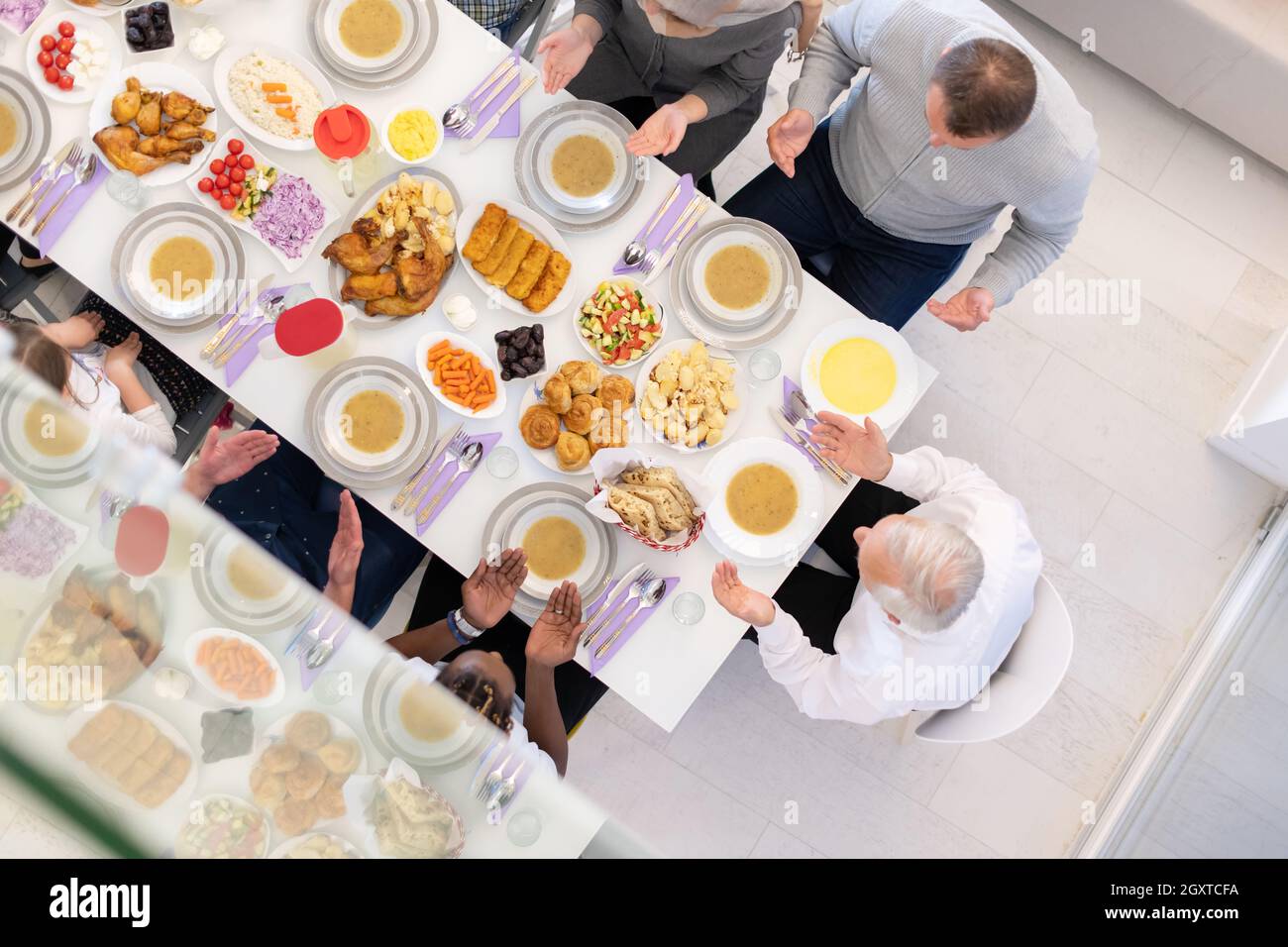 top view of modern multiethnic muslim family praying before having ...