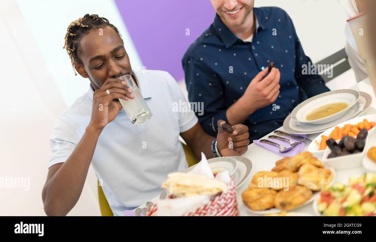 african american man enjoying iftar dinner together with modern ...