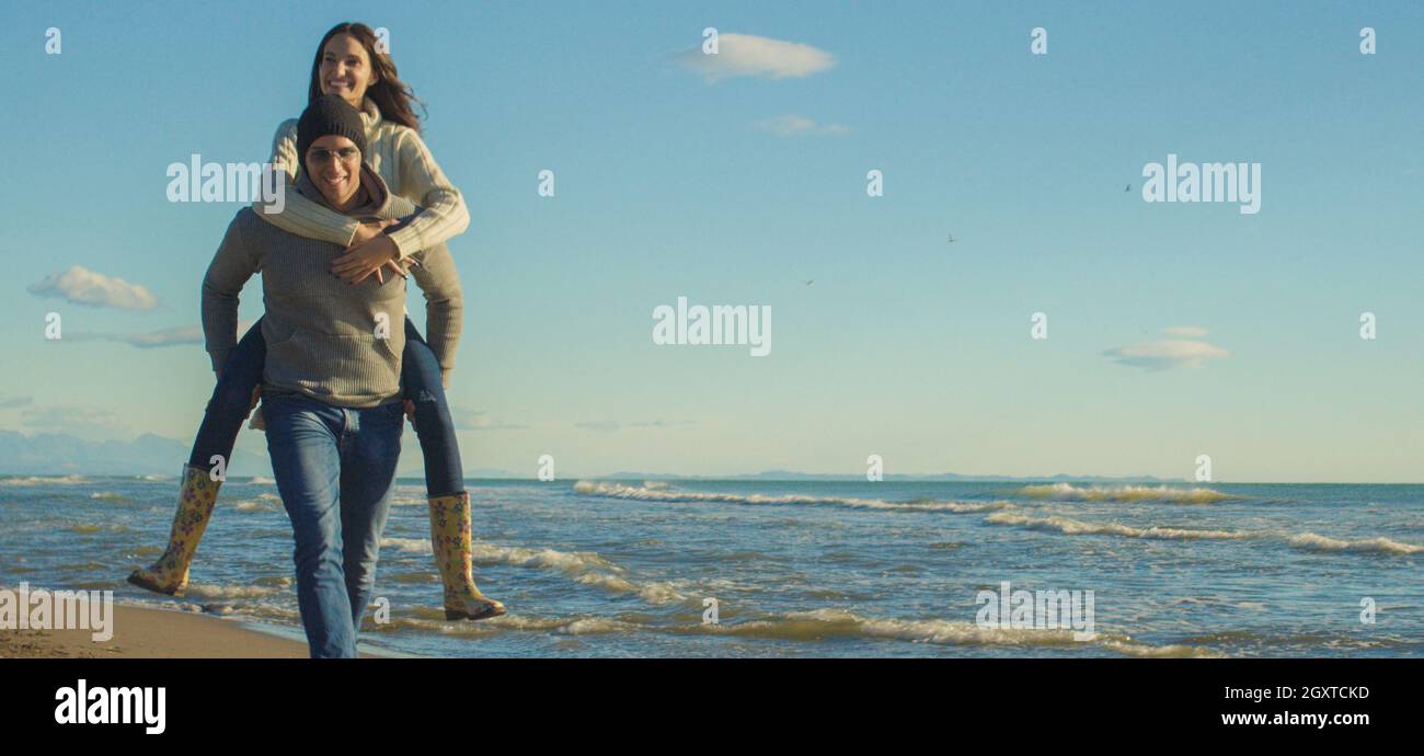 Men Giving Piggy Back Rides At Sunset By The Sea, autumn time Stock ...