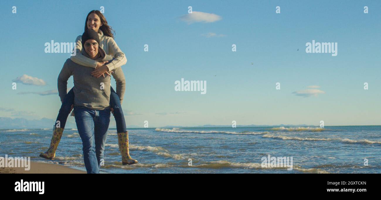 Men Giving Piggy Back Rides At Sunset By The Sea, autumn time Stock ...