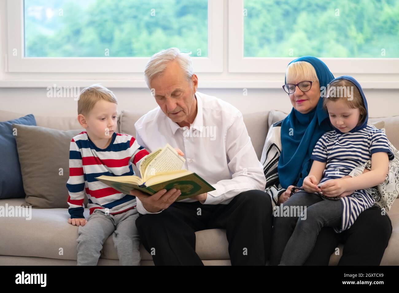 modern muslim family grandparents with grandchildren reading Quran and ...