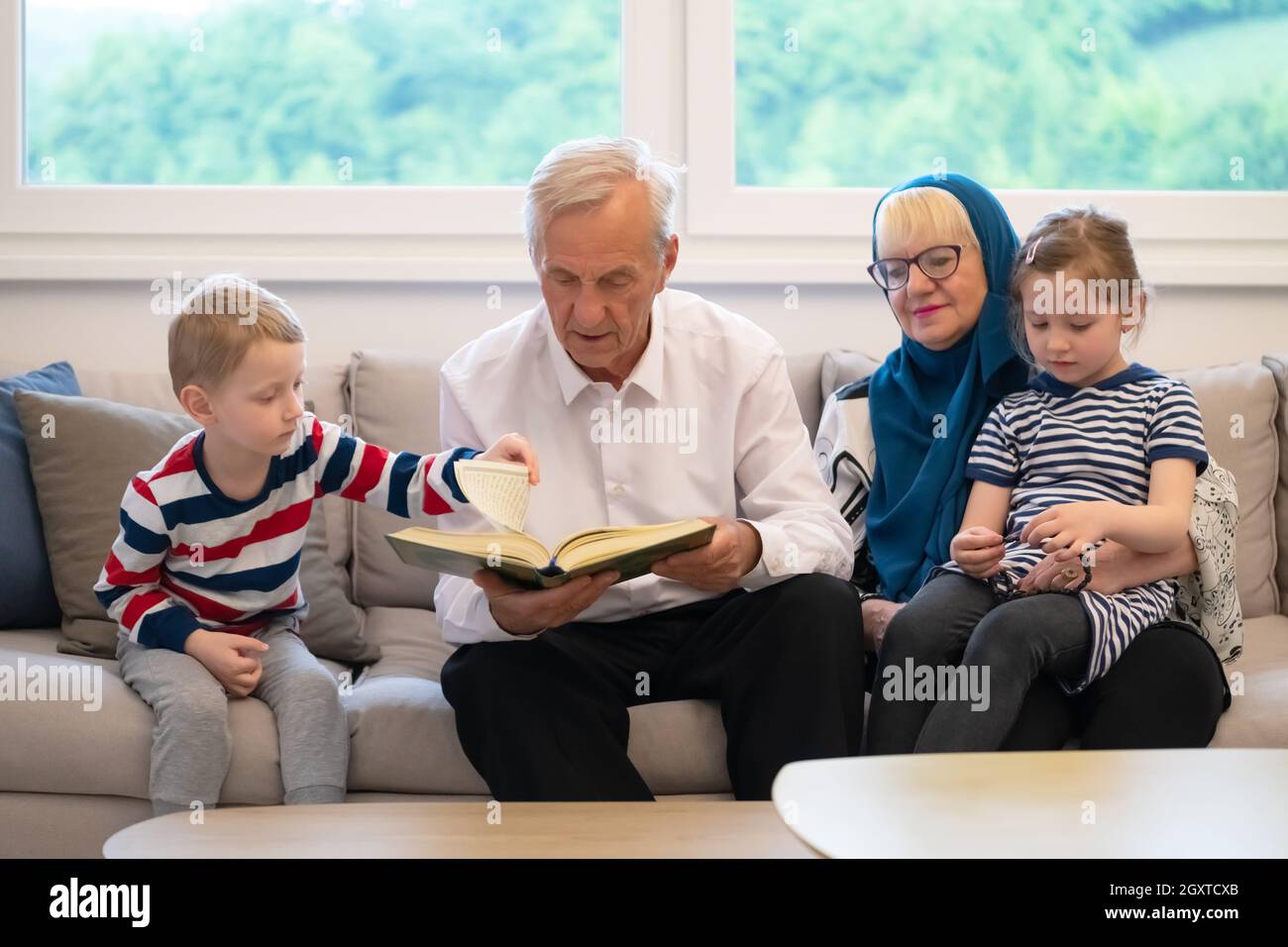 modern muslim family grandparents with grandchildren reading Quran and ...