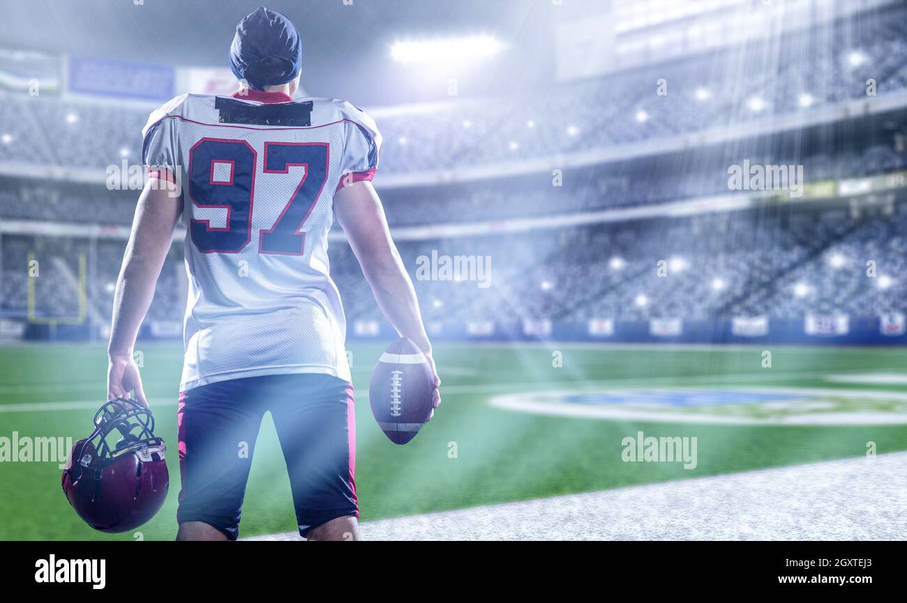 rear view of young confident American football player on the field of ...
