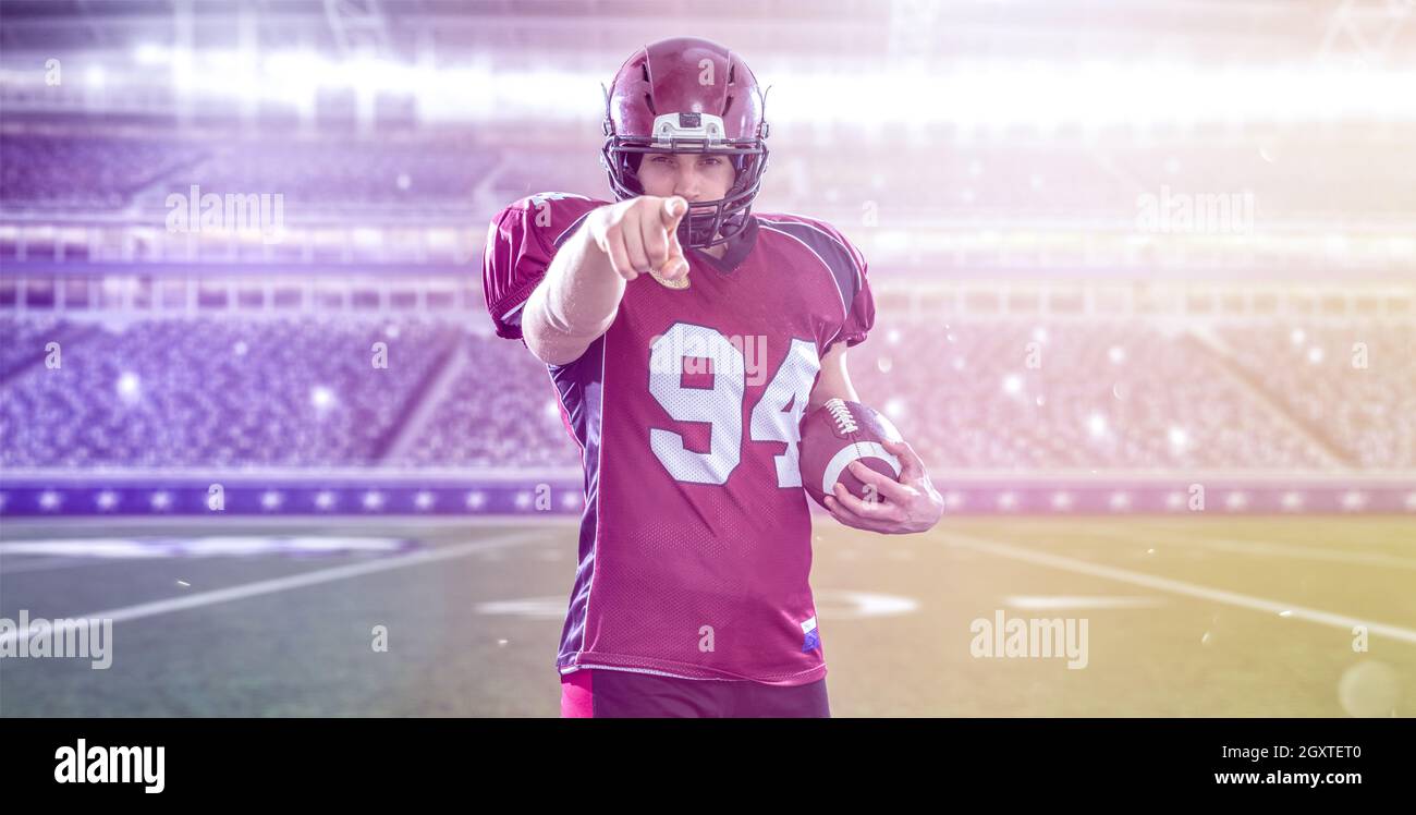 Portrait of American football player pointing against gray background ...