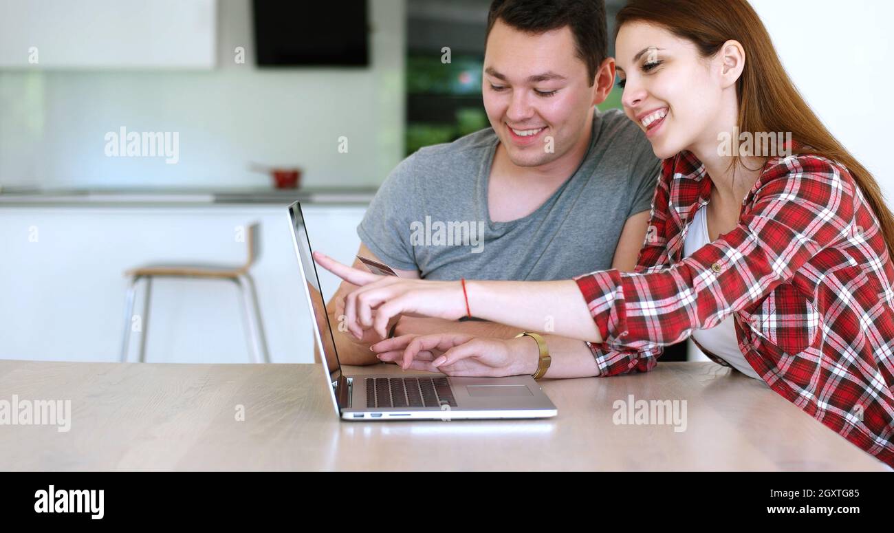 Couple sitting at table making online purchase using credit card Stock ...