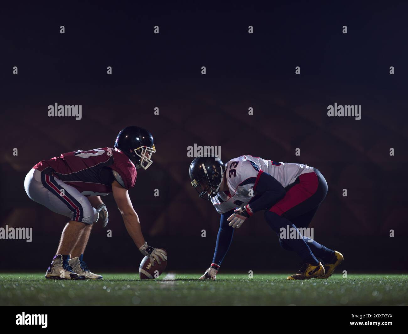 american football players are ready to start on field at night Stock ...