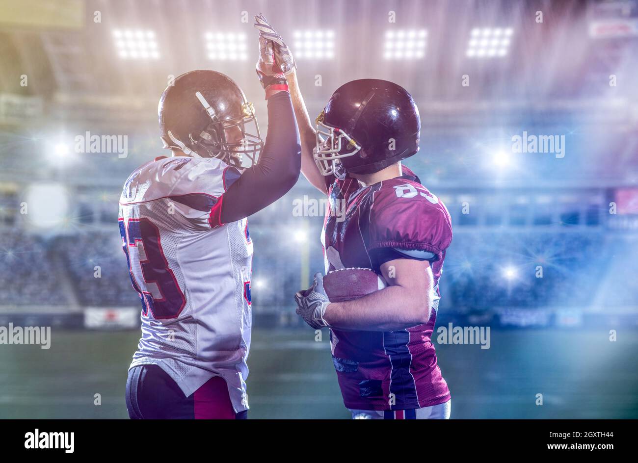 american football players giving high fives after scoring a touchdown ...