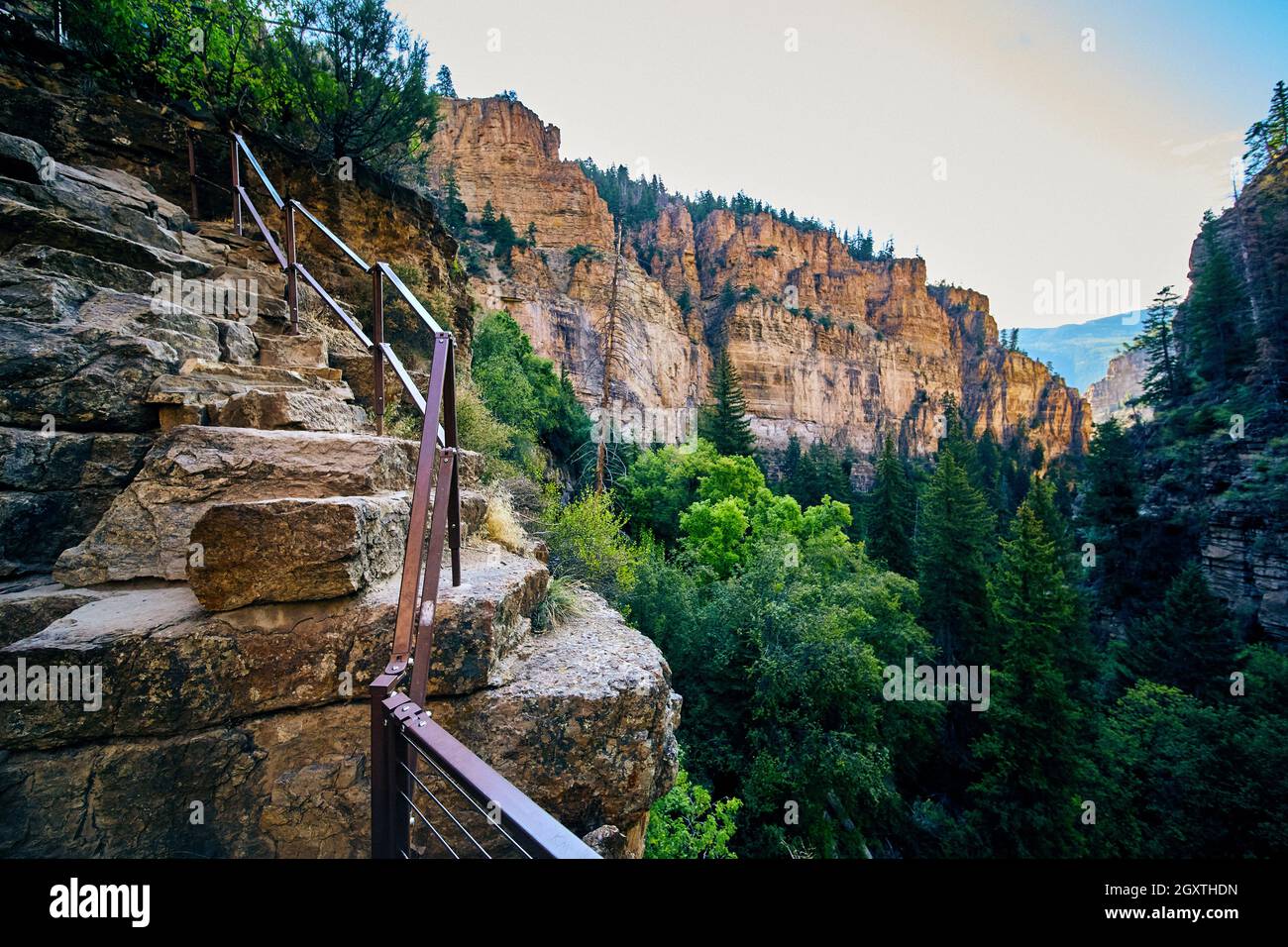 Stone steps in mountains with metal railing leading up mountain with ...