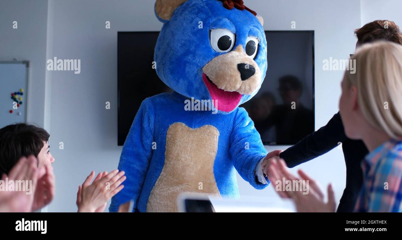 Boss dresed as teddy bear having fun with bussines people in modern ...
