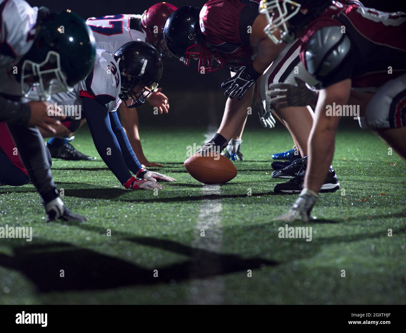 american football players are ready to start on field at night Stock ...