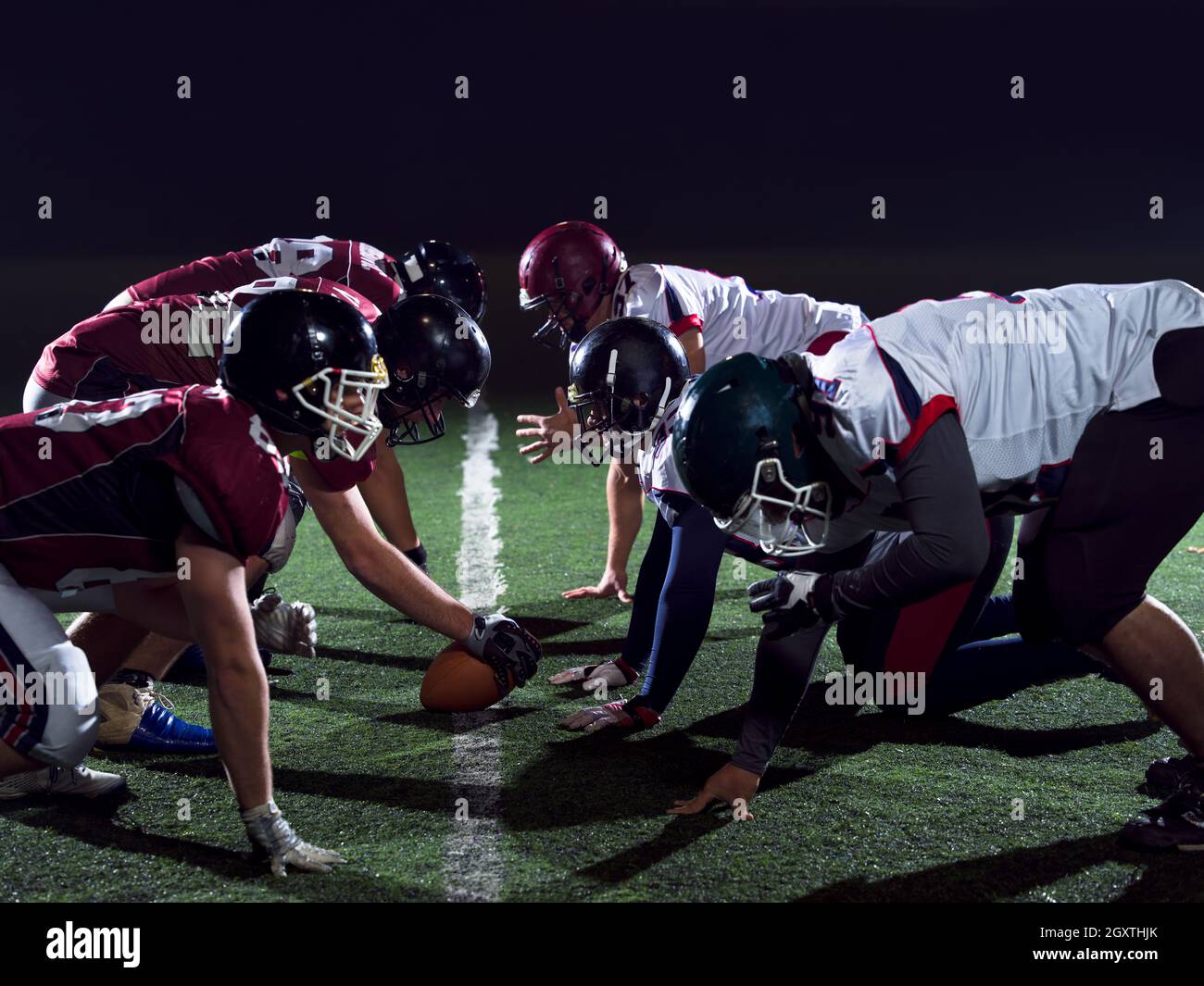 american football players are ready to start on field at night Stock ...
