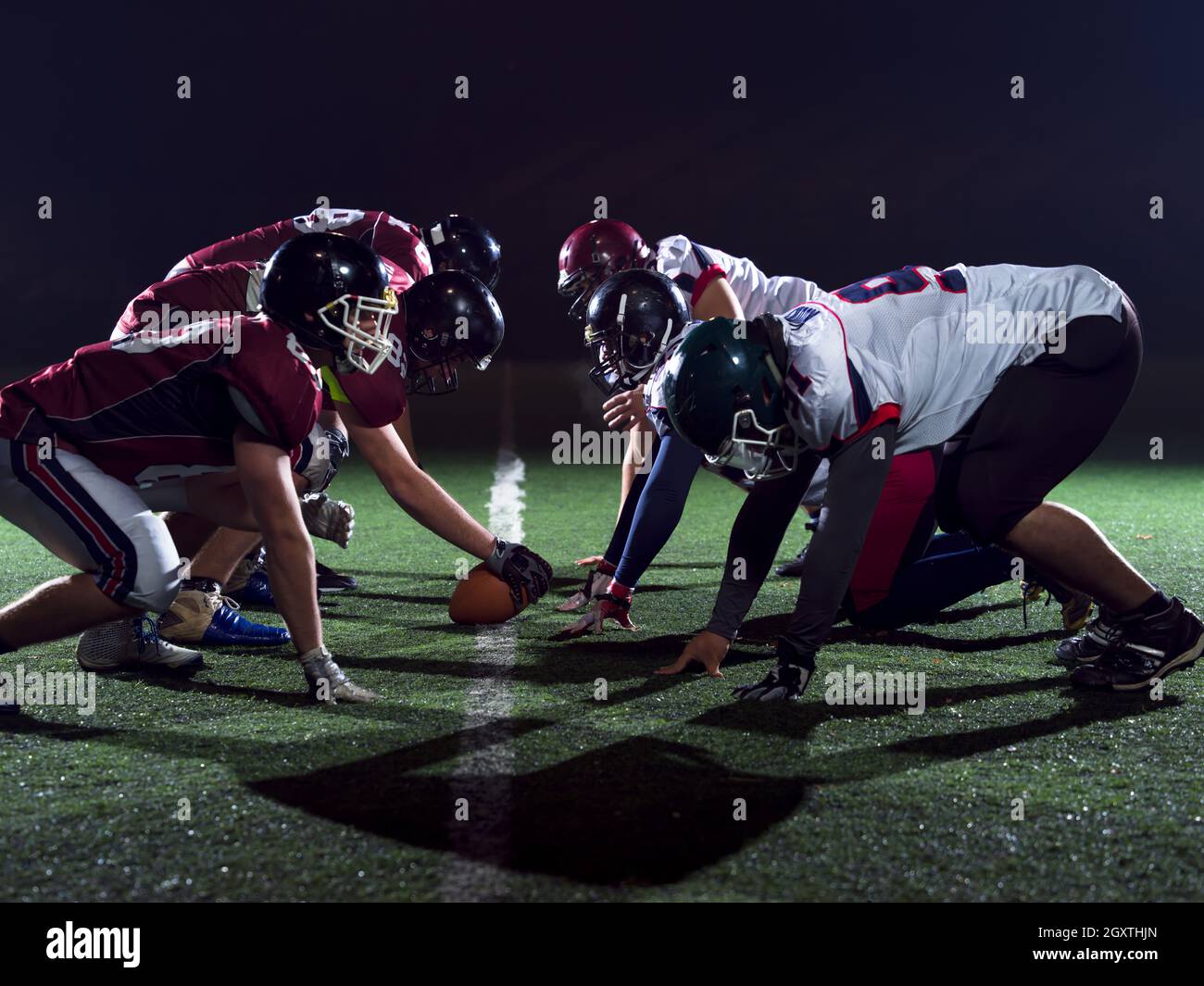 american football players are ready to start on field at night Stock ...