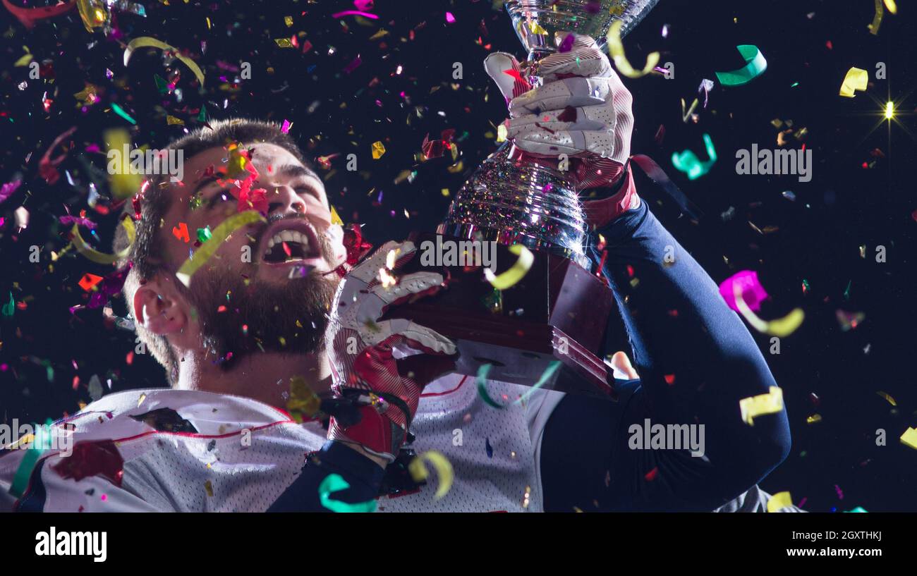 happy american football team celebrating victory with trophy and ...