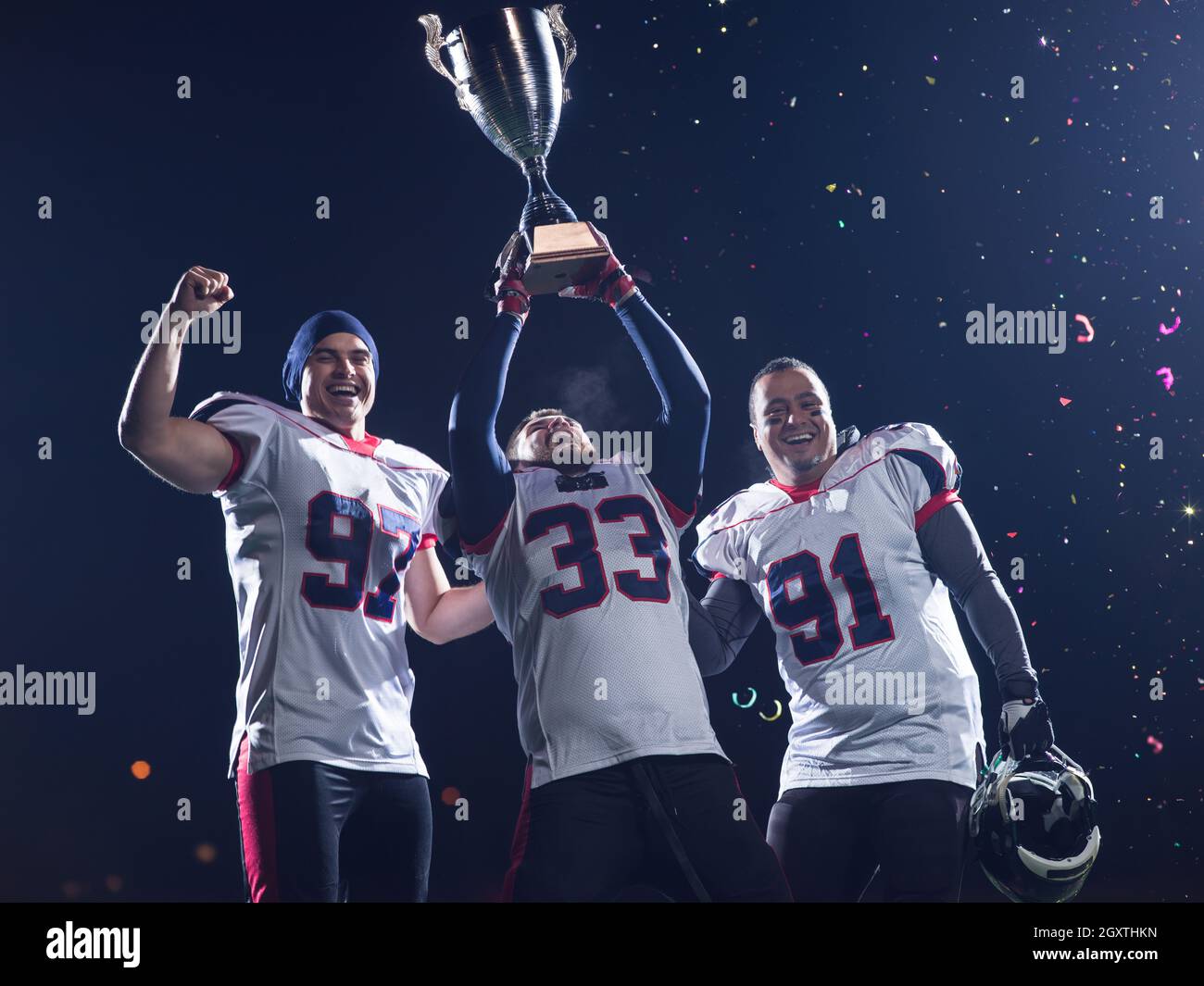 happy american football team celebrating victory with trophy and ...