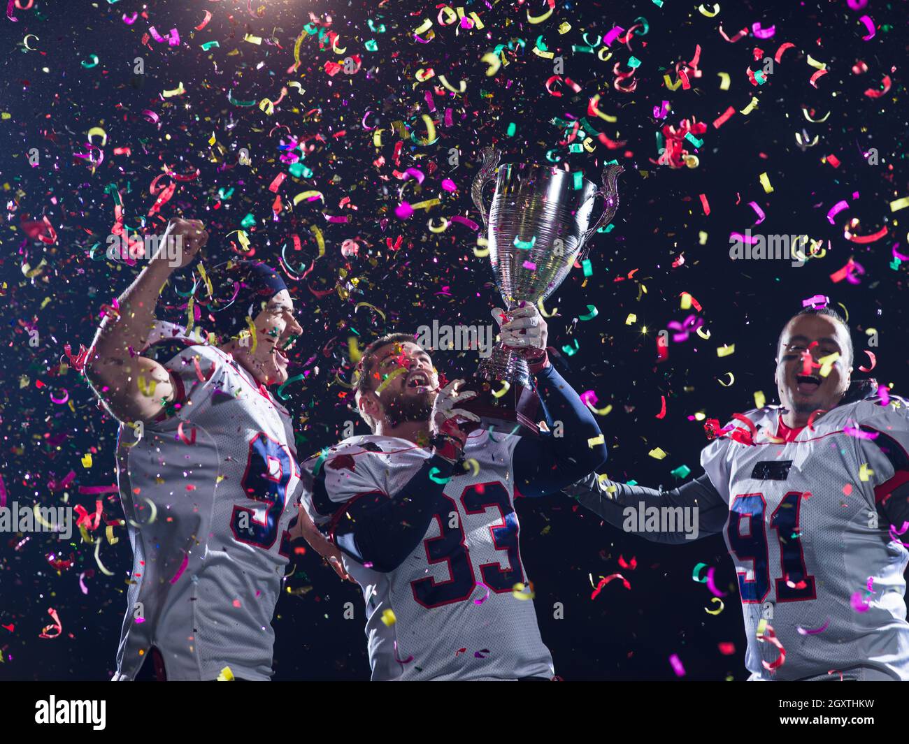 happy american football team celebrating victory with trophy and ...