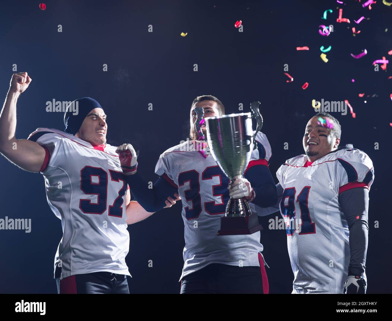 happy american football team celebrating victory with trophy and ...