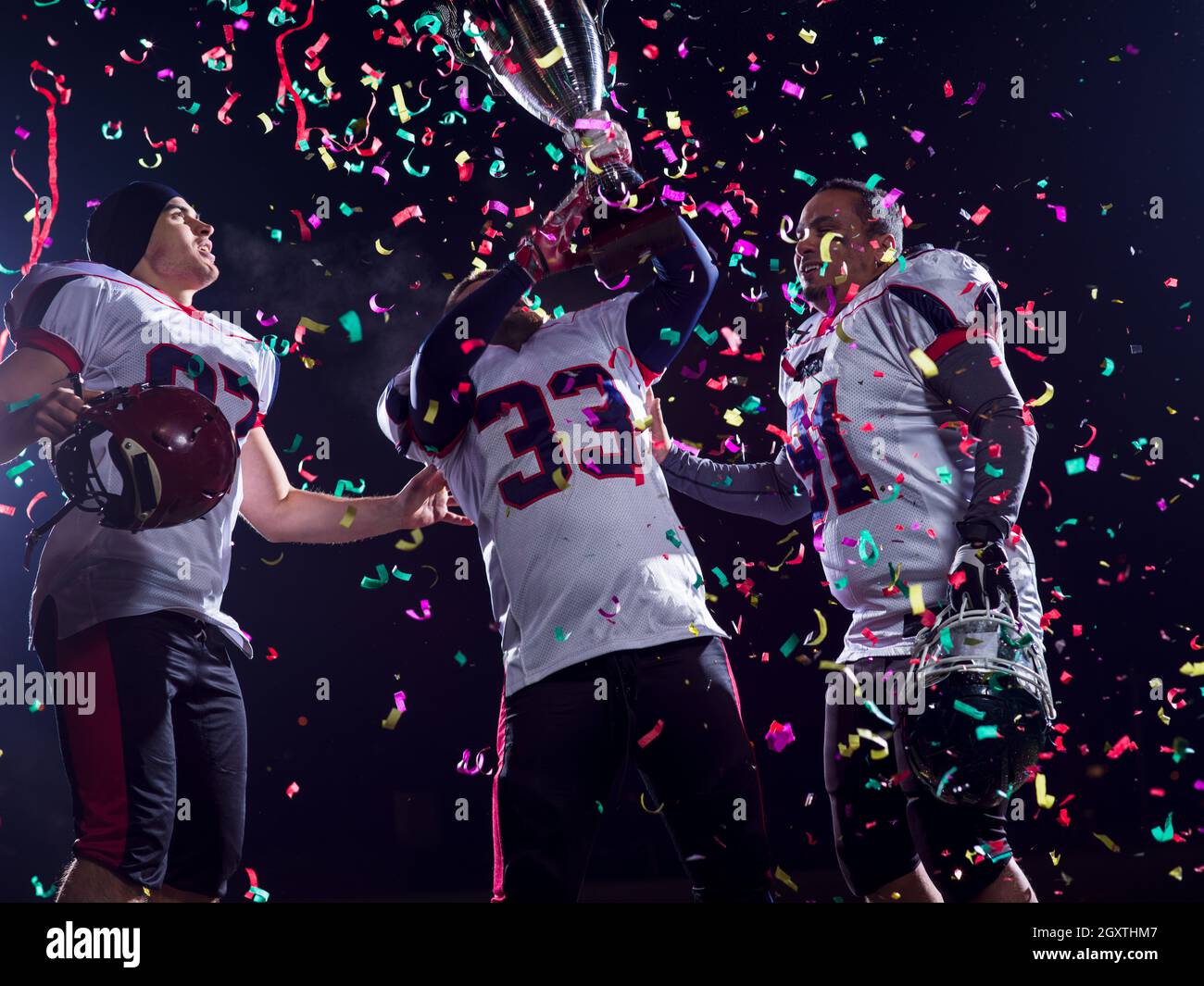 happy american football team celebrating victory with trophy and ...