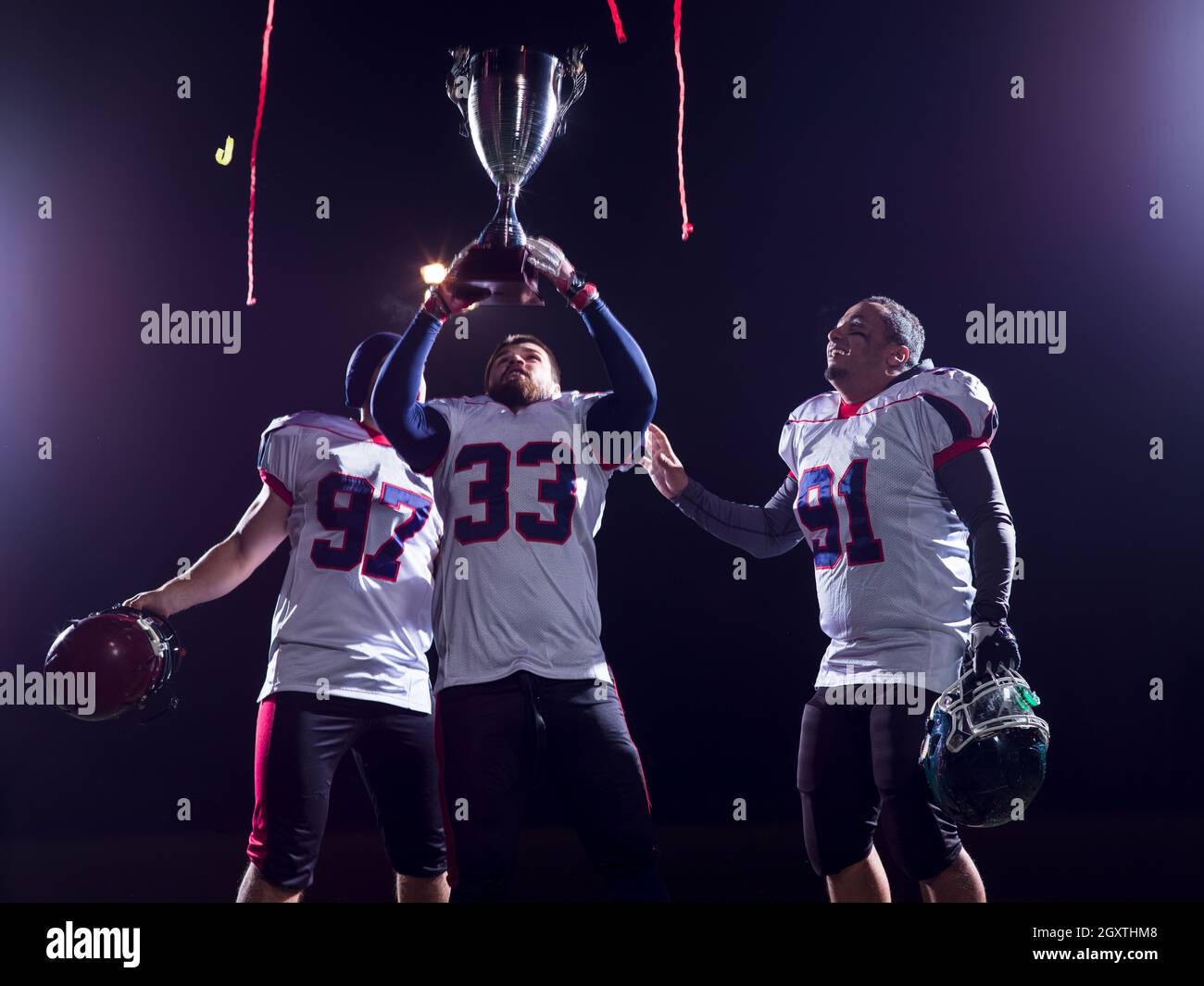happy american football team celebrating victory with trophy and ...