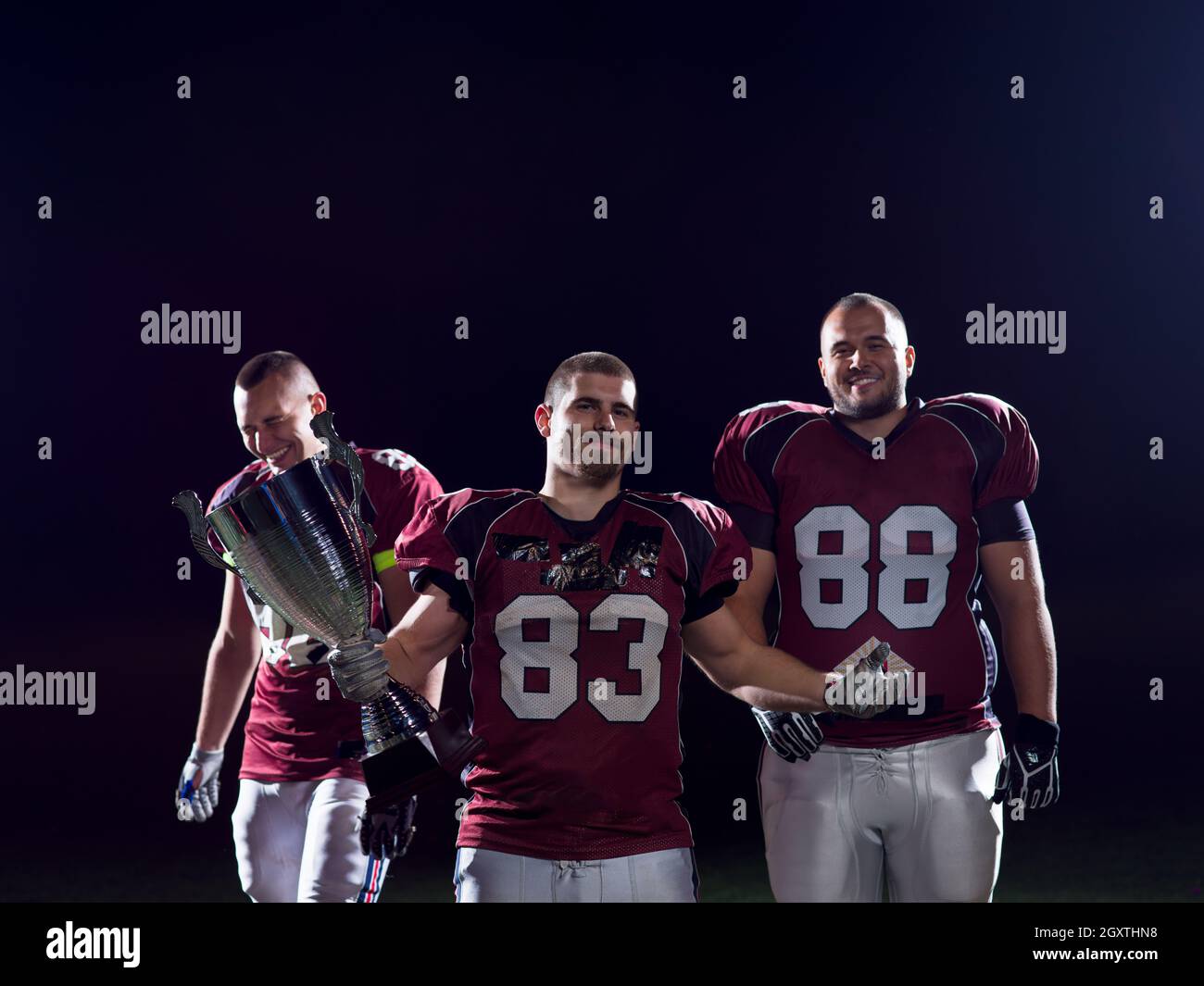happy american football team with trophy celebrating victory on night ...