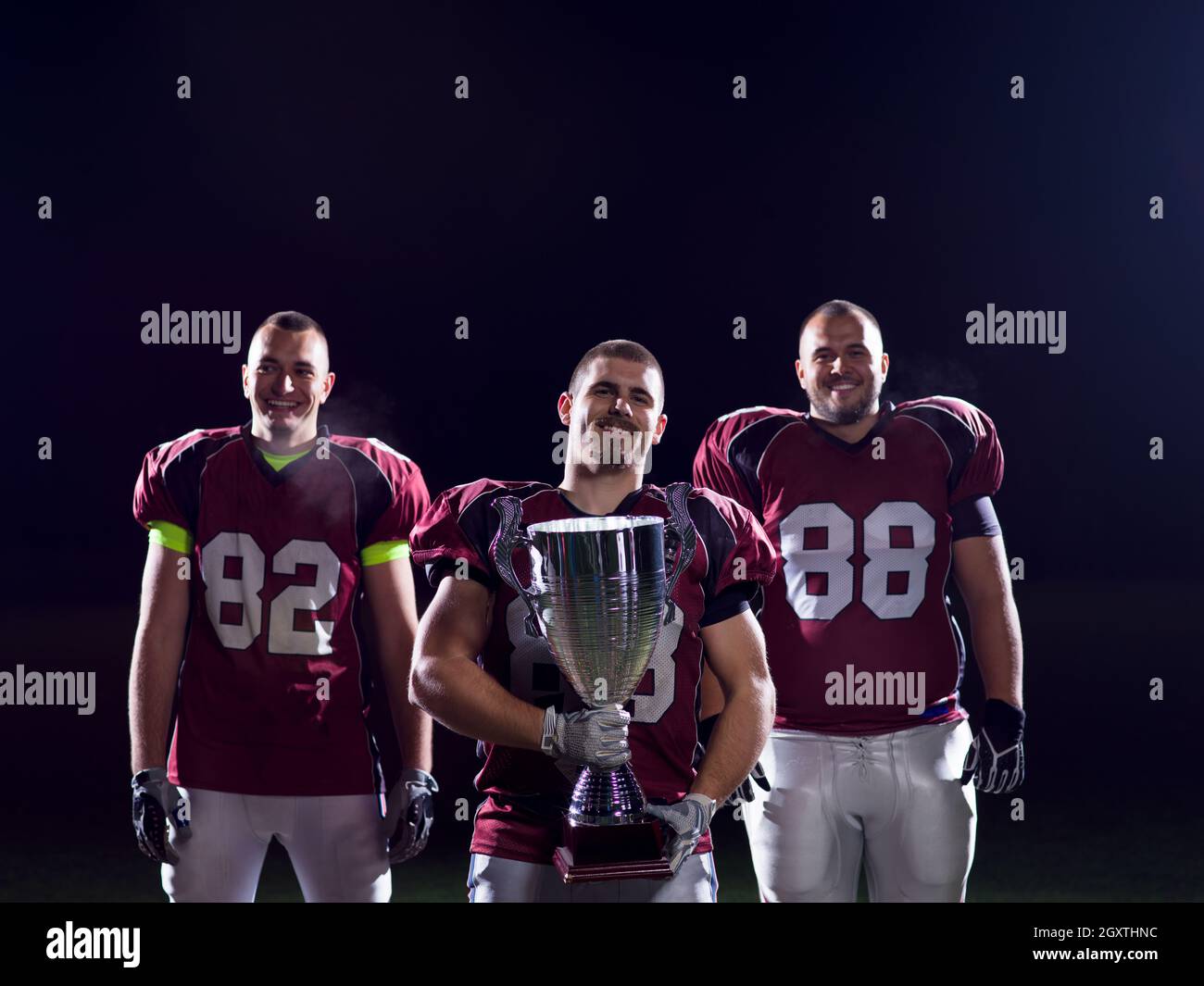 happy american football team with trophy celebrating victory on night ...