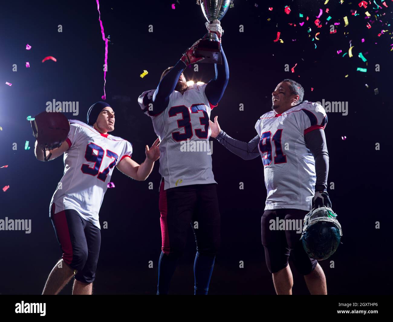 happy american football team celebrating victory with trophy and ...