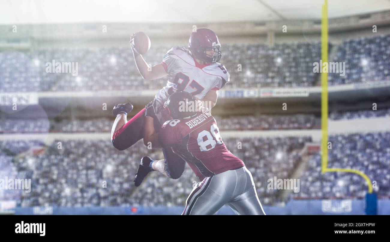 American football players in action at night game time on big modern ...